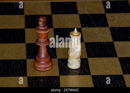 Two opposing Kings represented by chess stand facing each other. A ...