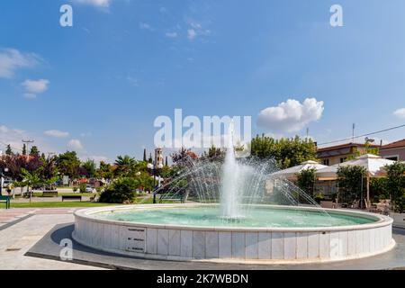 Springbrunnen im Park von Agios Athanasios in Griechenland mit Kirche ...