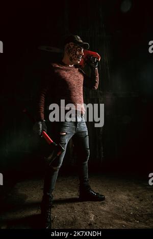 Evil in mask with chainsaw, horror Halloween scene in dark room Stock ...