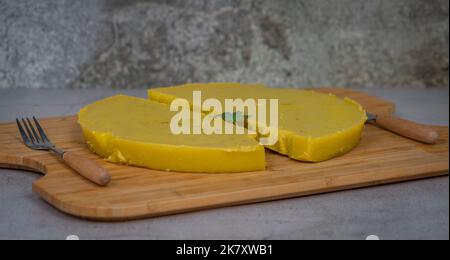 Yelllow marijuana butter on light stone table with dish towel and color ...