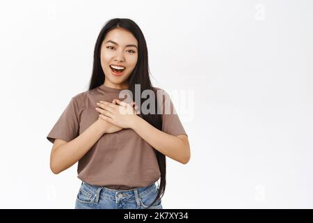 Beautiful korean girl looking with flattered, delighted face, pleased ...