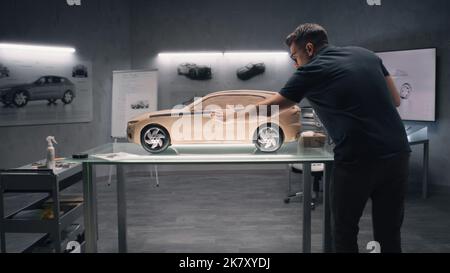 Two male automotive designers sculpting futuristic plasticine clay ...