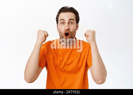 Image of enthusiastic adult man winning, celebrating victory, smiling ...