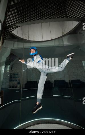 A woman flies in a wind tunnel. Free fall simulator Stock Photo - Alamy
