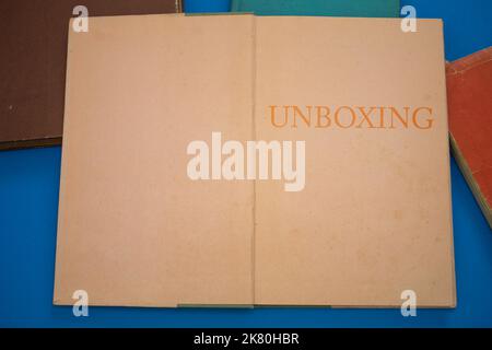 Unboxing word in opened book with vintage, natural patterns old antique ...