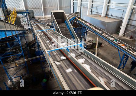 Conveyors carry trash and empty platforms at recycling plant Stock Photo - Alamy