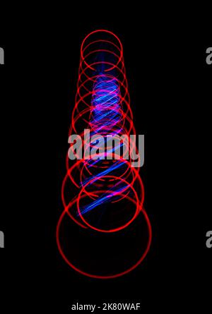 Whirling red light circles on black background Stock Photo - Alamy