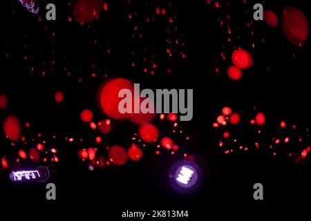 Red garlands on window. Lights in dark. Red lamps. Interior details ...