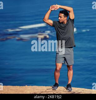 Young hispanic man stretching arms muscles outdoors Stock Photo - Alamy