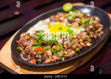 A steaming sizzling plate of Filipino sisig dish in Ozamiz City ...