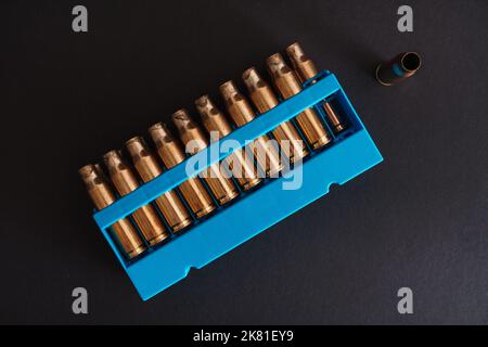Amber gold empty bullet cases in blue holder Stock Photo - Alamy