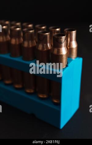 Amber gold empty bullet cases in blue holder Stock Photo - Alamy
