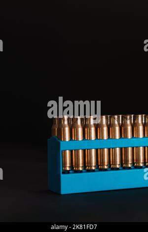 Amber gold empty bullet cases in blue holder Stock Photo - Alamy