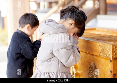 Japanese kids praying at the temple Stock Photo - Alamy