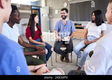 Students sitting in circle working together Stock Photo - Alamy