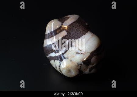Zebra jasper chalcedony tumbled stone macro isolated on black ...