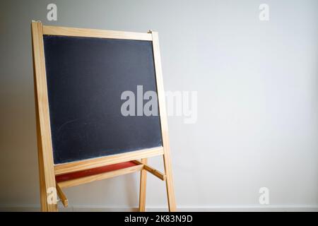 An empty black board against white wall Stock Photo - Alamy