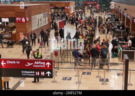 Travelers stand in line at a security checkpoint before boarding their ...