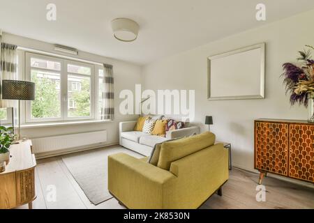 Table with chairs located near lounge area and kitchen in spacious room ...