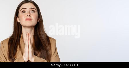 Hopeful corporate woman, student praying, begging god, looking up and ...