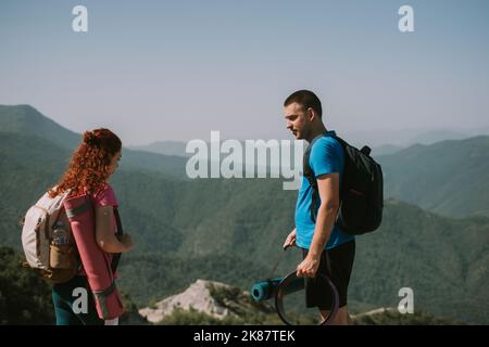 Yoga partners standing at the top of the mountain Stock Photo - Alamy