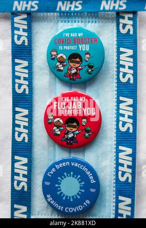Colourful Covid 19 Booster and Flu Jab badges laying on top of a ...