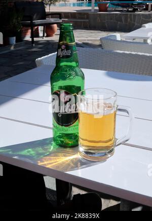 Single Green Mythos Greek beer bottle - and glass of Mythos partially ...