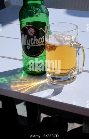 Single Green Mythos Greek beer bottle - and glass of Mythos partially ...