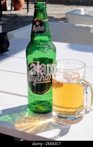 Single Green Mythos Greek beer bottle - and glass of Mythos partially ...