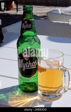 Single Green Mythos Greek beer bottle - and glass of Mythos partially ...