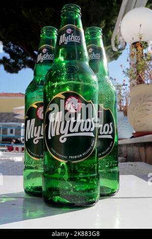 Three Green Mythos Greek beer bottles outdoors on a sunny day. Sept ...
