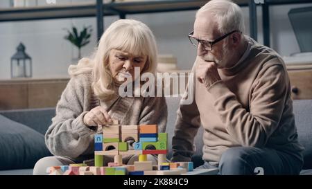 retired couple with dementia playing with colorful building blocks on ...