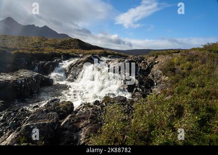 A view of the Sligachan waterfalls with views of the Cuillin mountains ...