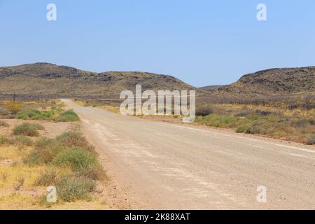 Namibian landscape along the gravel road. Red ground and African ...