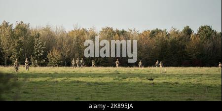 British army soldiers crossing open ground, weapons ready on a military ...