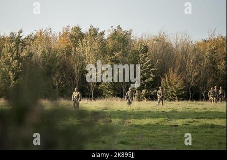 British army soldiers crossing open ground, weapons ready on a military ...