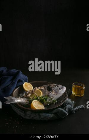 Raw fish presented in a metal dish on a dark background Stock Photo - Alamy