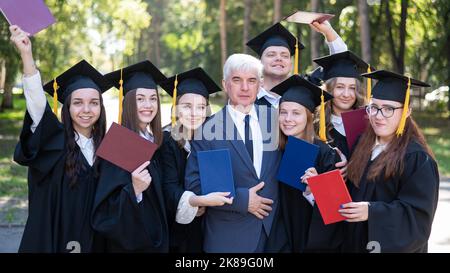 University professor and seven graduates rejoice at graduation Stock ...
