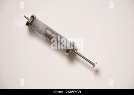 interchangeable old glass syringe on a white background, injections and ...