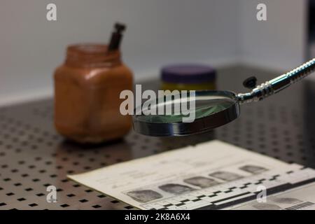 Forensic ruler, magnifying glass, fingerprint card and a jar of ...