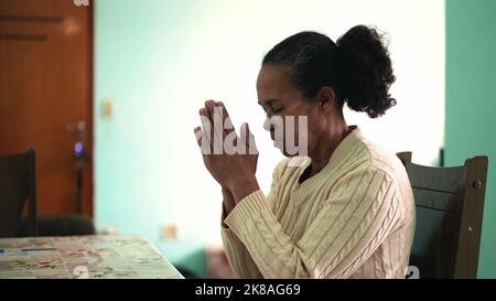One meditative black woman praying. A contemplative African American ...