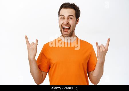 Handsome happy guy shows rock on, heavy metal sign, enjoying smth ...