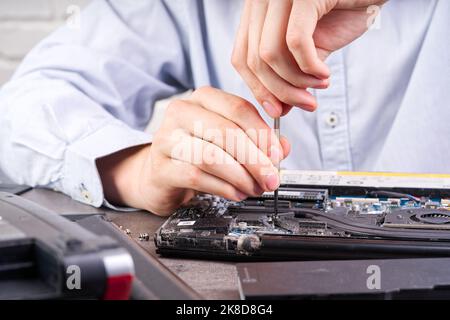 Man disassembles a laptop. Computer service and repair concept. Laptop ...