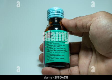 Hand holding a bottle of paracetamol syrup on a white background Stock ...