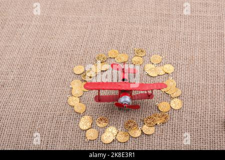 Fake gold coins around the retro model airplane Stock Photo - Alamy