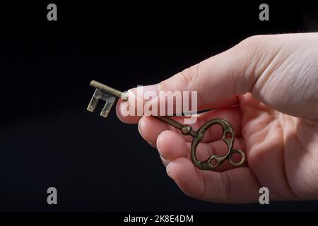 Hand holding a retro styled golden color decorative key Stock Photo - Alamy