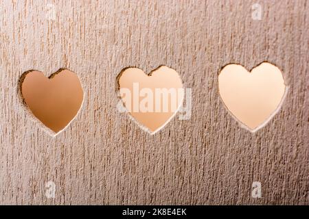 Heart shape holes on a wooden object Stock Photo - Alamy
