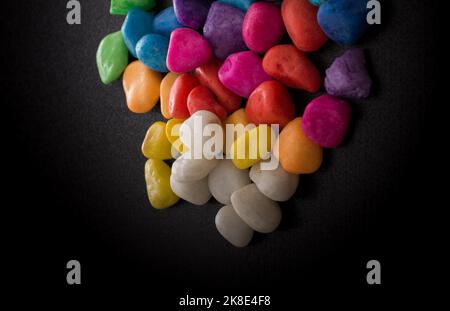 Pile of little colorful pebbles on black background Stock Photo - Alamy