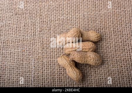 Peanuts with shell on linen canvas background Stock Photo - Alamy