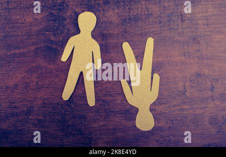 Man shape cut out of paper in wallet in hand Stock Photo - Alamy